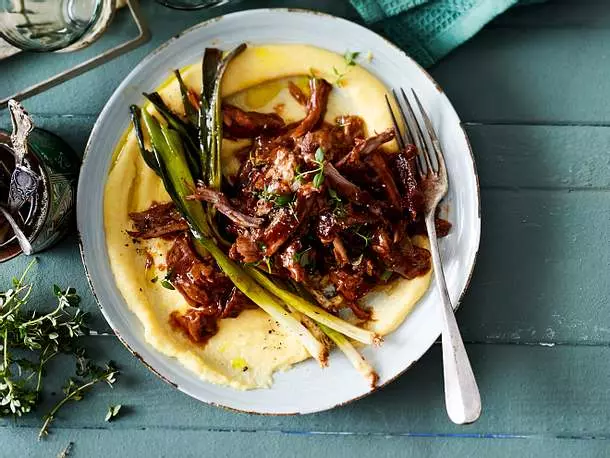 Receta de pierna de cordero desmenuzada sobre polenta cremosa